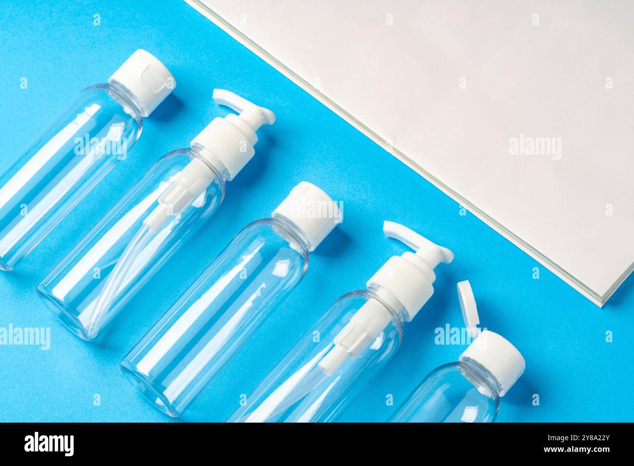 Various clear plastic bottles and containers arranged on a blue ...