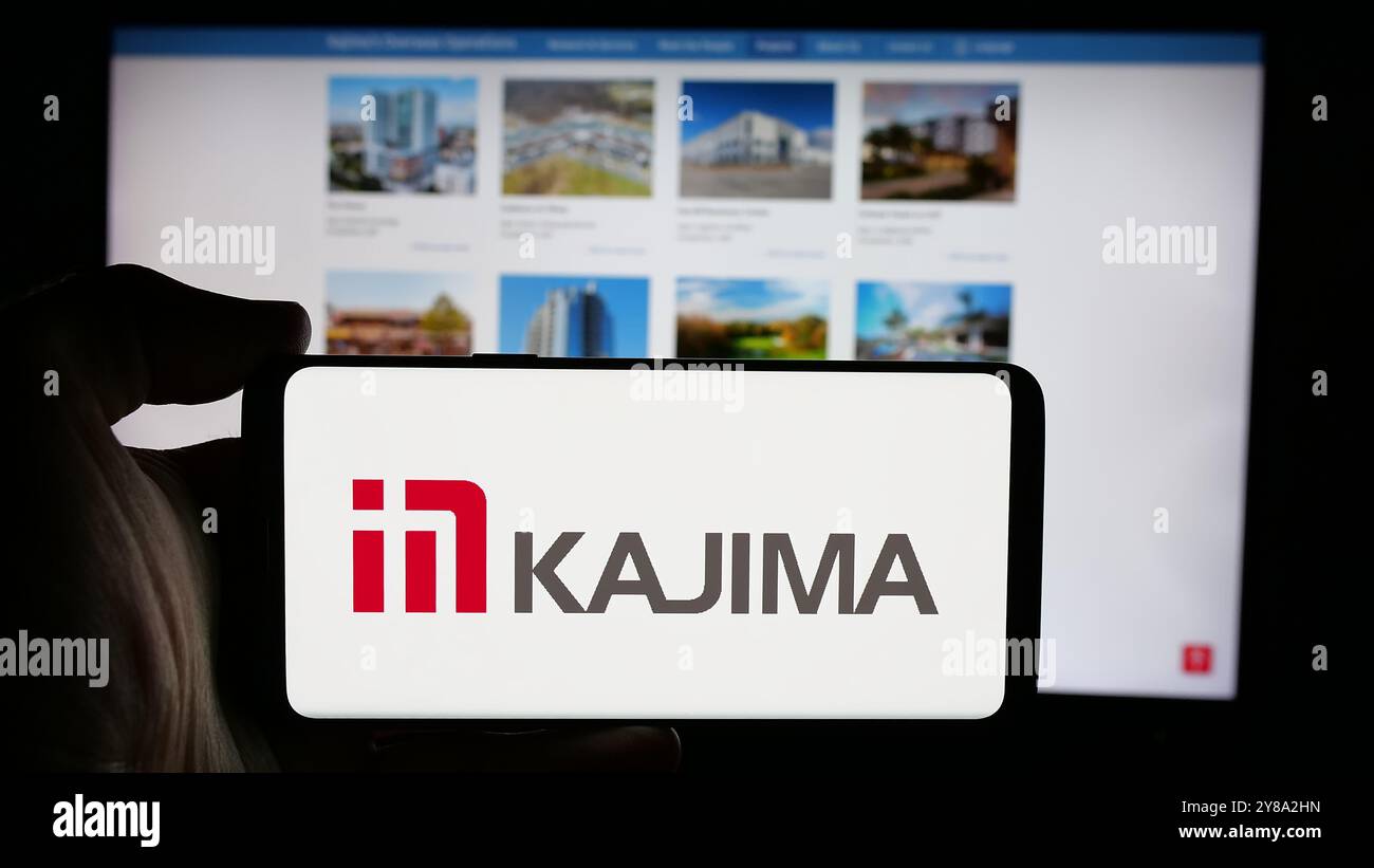 Person holding cellphone with logo of Japanese construction company ...