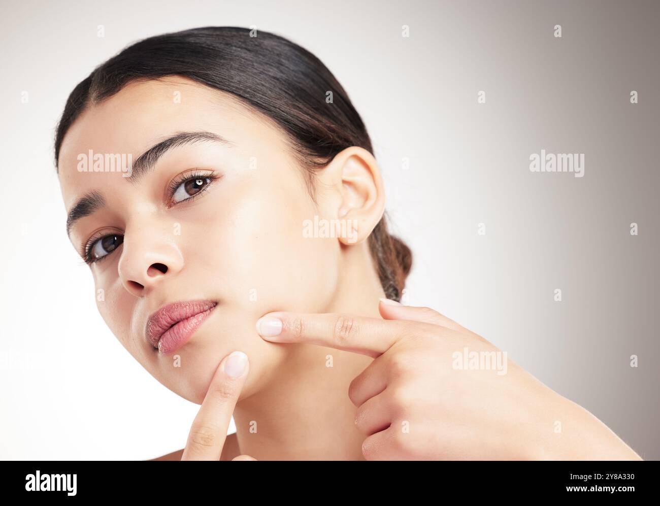 Portrait, woman and pop pimple in studio for skincare breakout, acne ...