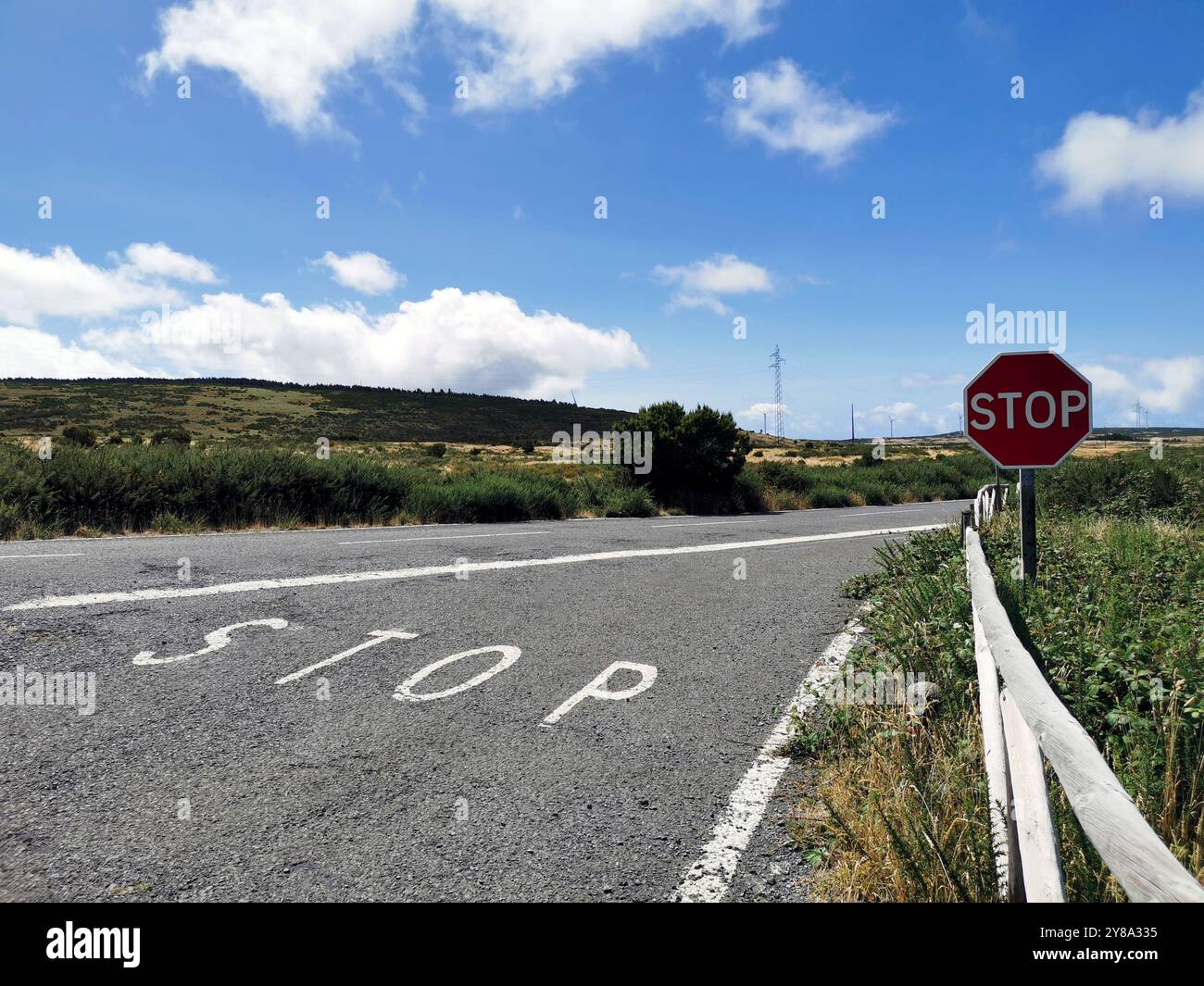This photo highlights a bold "STOP" sign on a quiet country road in ...