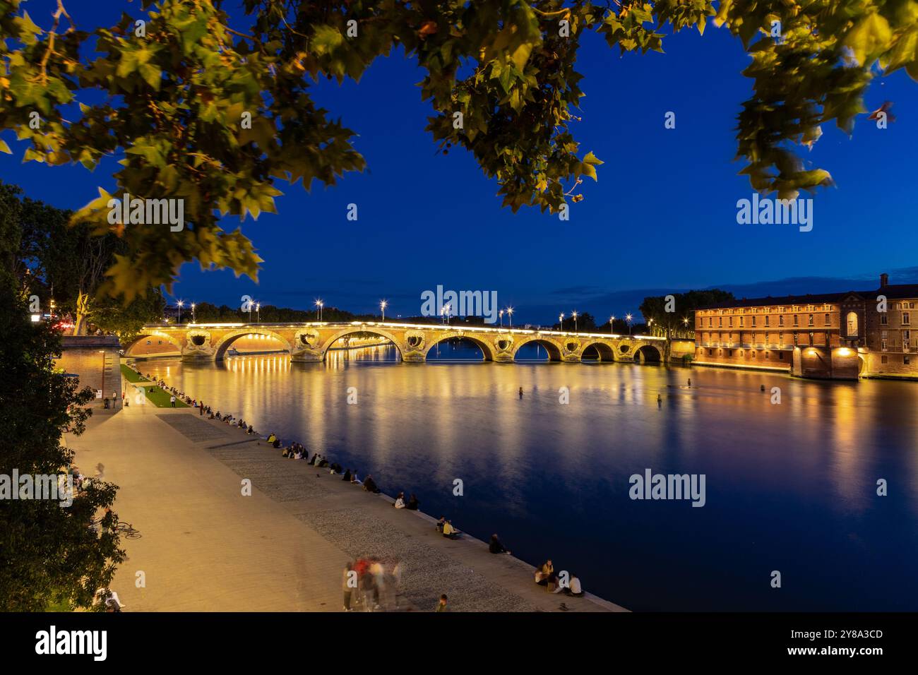 Golden sunset over the Garonne river and Pont Neuf in downtown Toulouse. This arch bridge is ...
