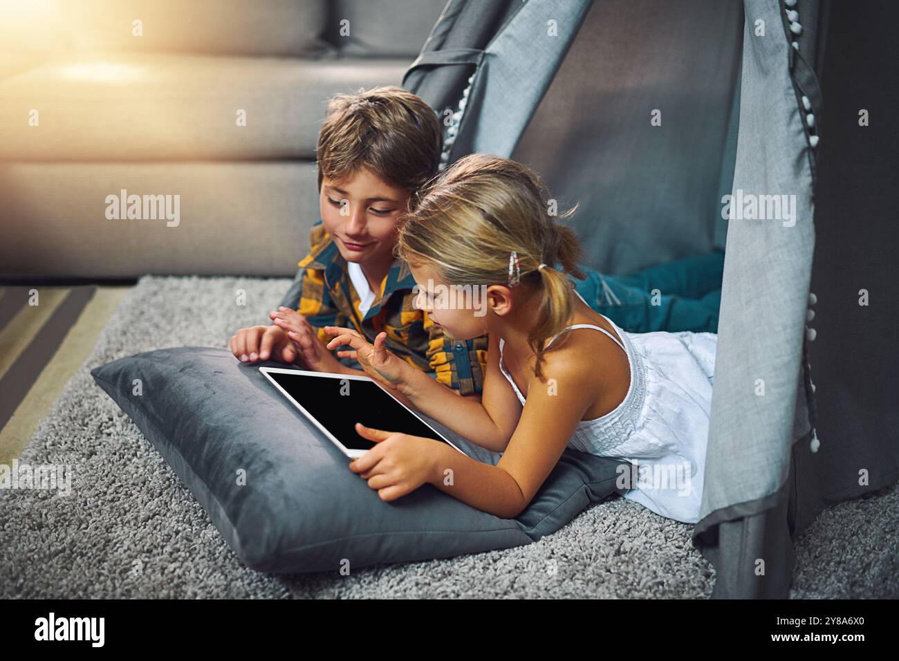 Tablet, relax and kids in tent in home playing online educational game ...
