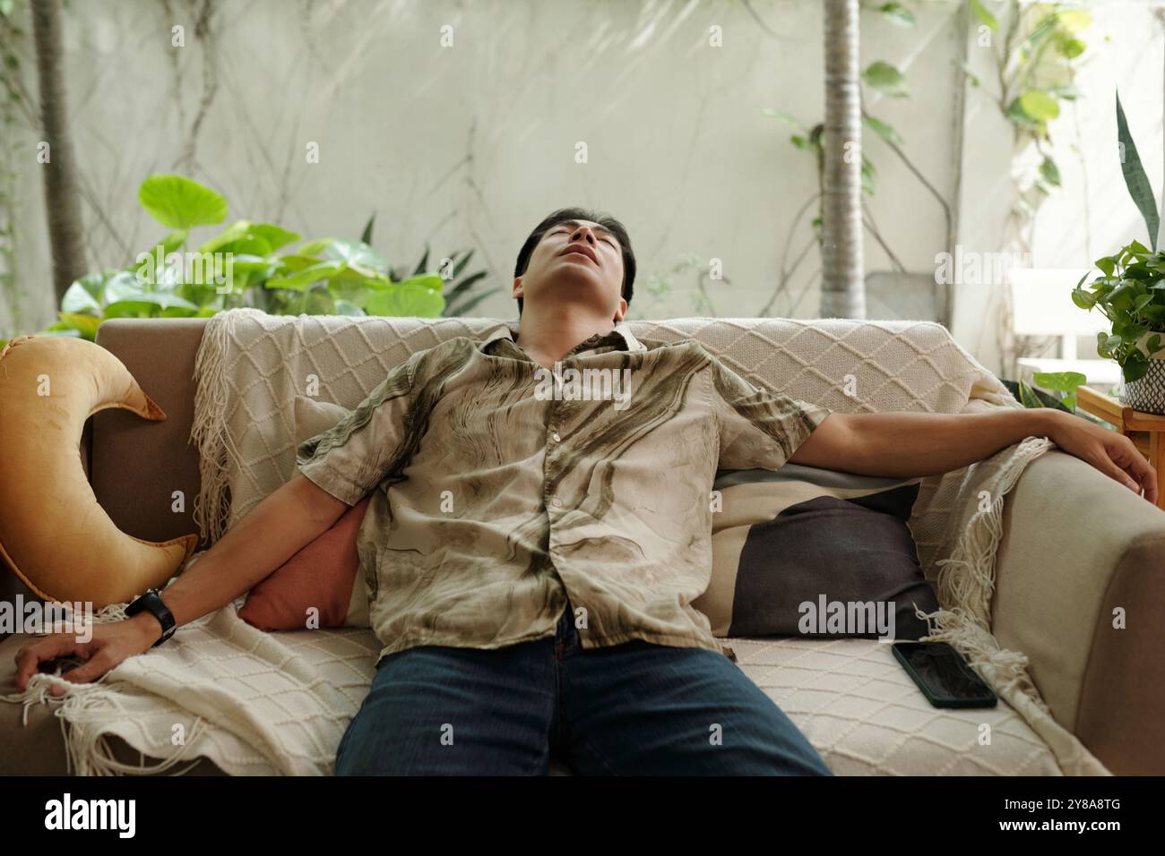 Depressed man sleeping on sofa hi-res stock photography and images - Alamy