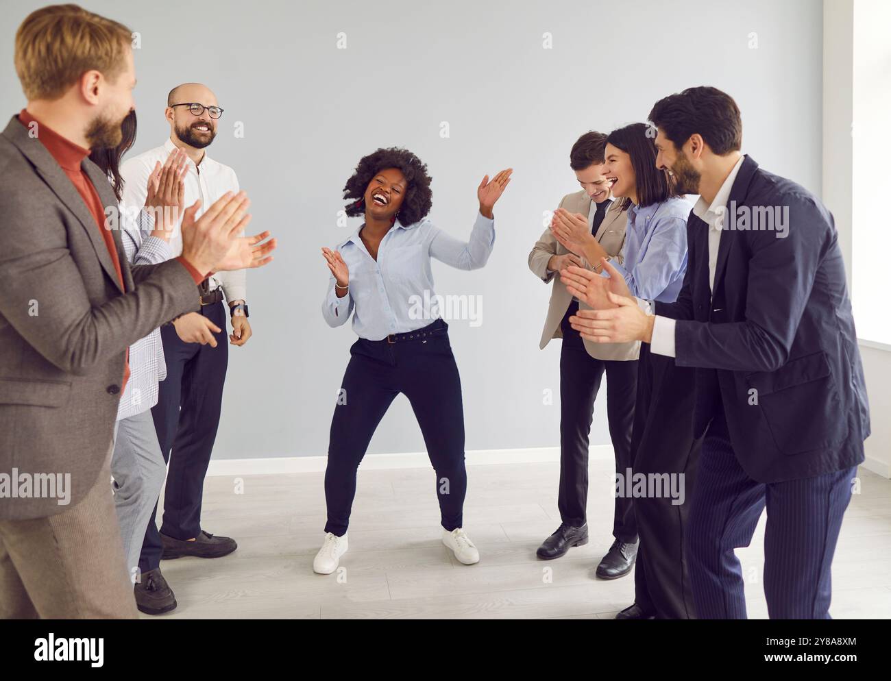Company employees celebrating success congratulating female colleague ...