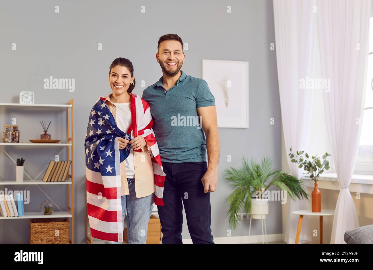 Happy American Family Couple Wrapped In The American Flag At Home Stock ...