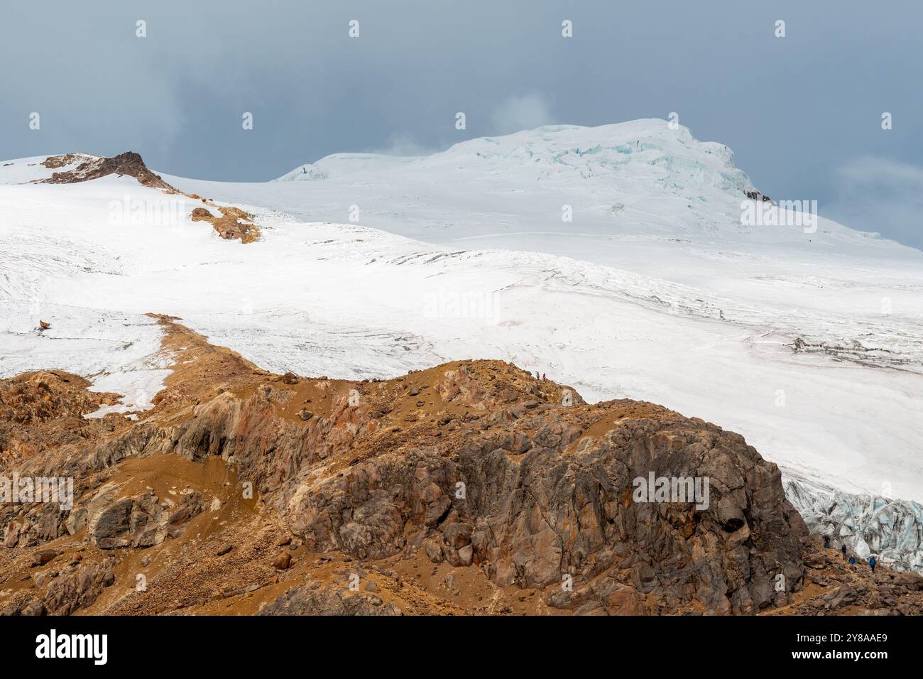 Cayambe volcano peak glacier with people silhouettes hiking the descent ...