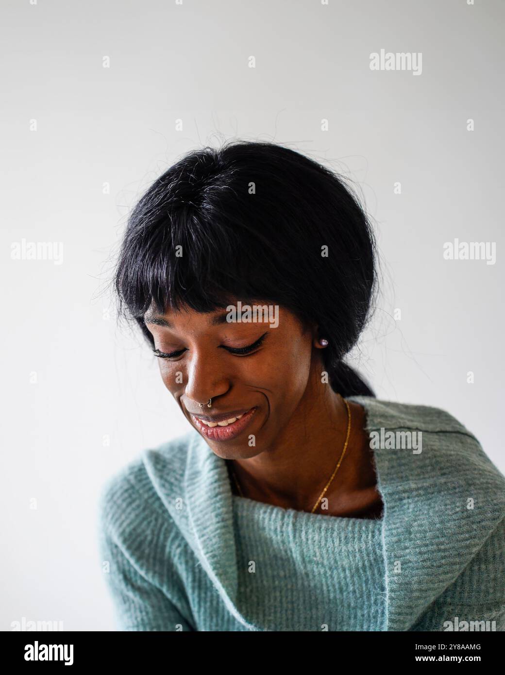 Young black woman on the verge of tears with a strained smile, captured ...
