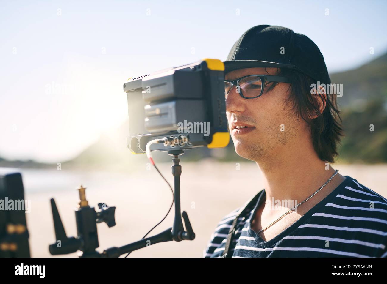 Photographer, man and filming with camera on beach for nature scenery ...