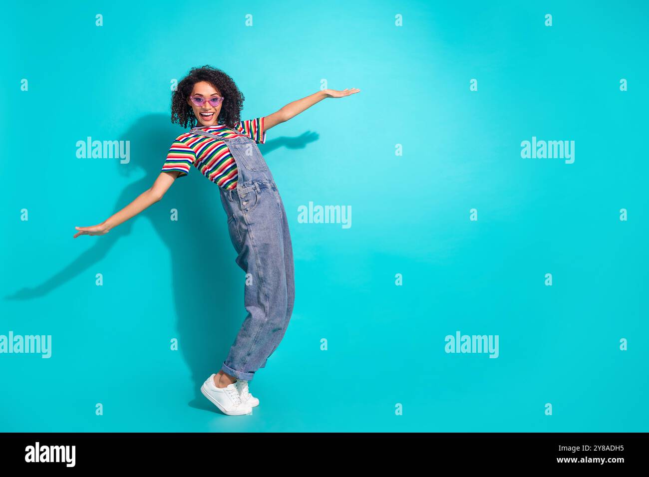 Photo of positive cheerful girl dancing near copyspace isolated blue ...