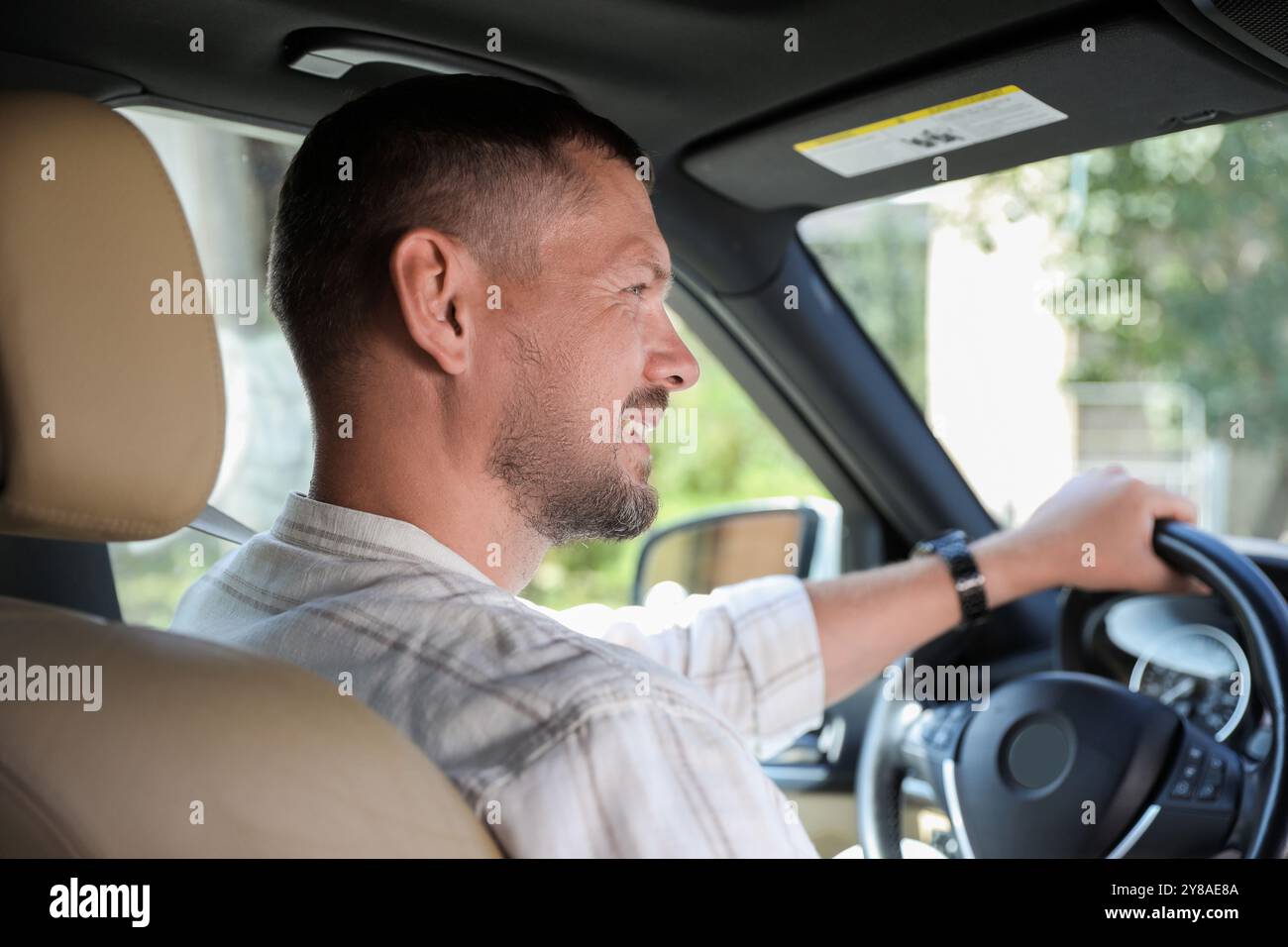 Happy man holding steering wheel while driving car Stock Photo - Alamy