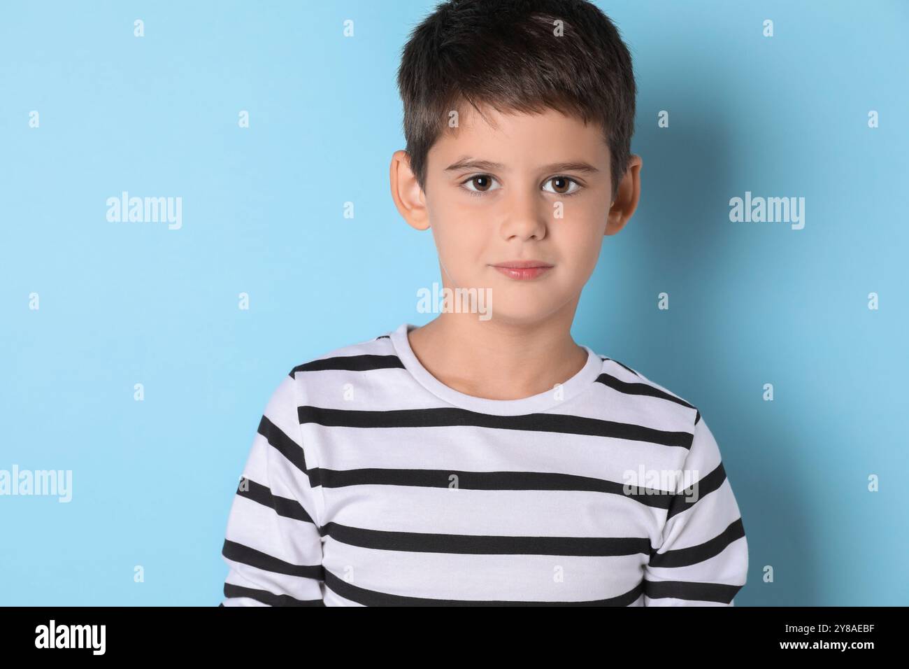Portrait of cute little boy on light blue background Stock Photo - Alamy