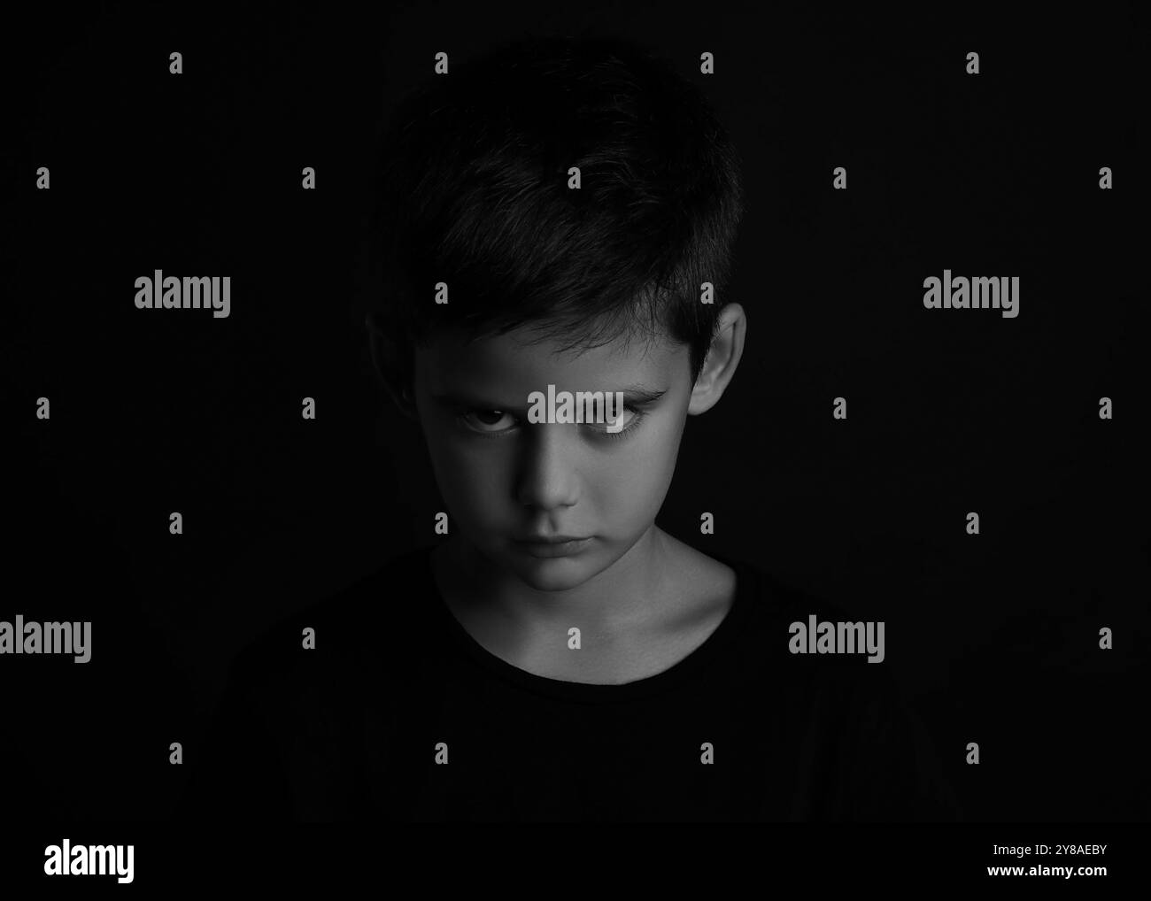 Angry little boy on dark background. Black and white effect Stock Photo ...