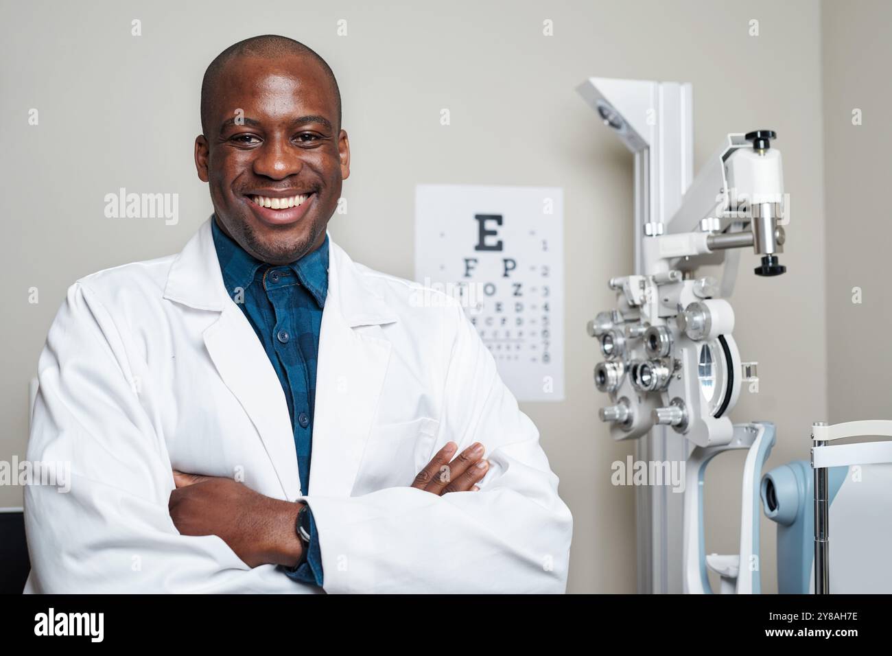 Confident Optometrist in White Coat Smiling in Modern Office with Eye ...
