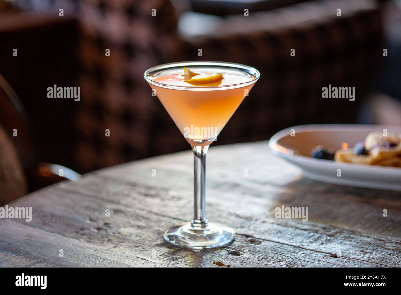 Gold colored cocktail in a martini glass with garnish Stock Photo - Alamy