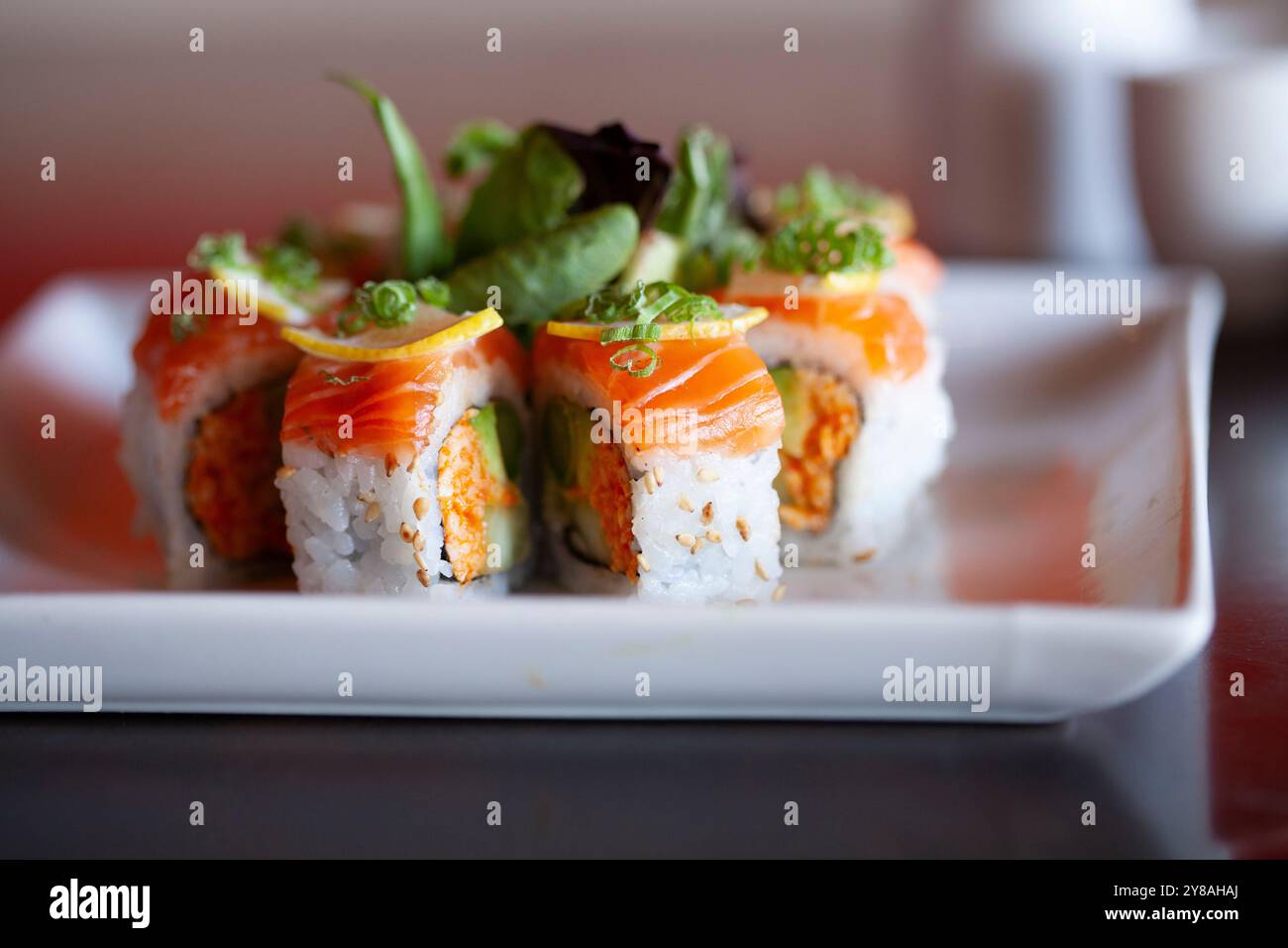 Sushi roll neatly plated with garnish Stock Photo - Alamy