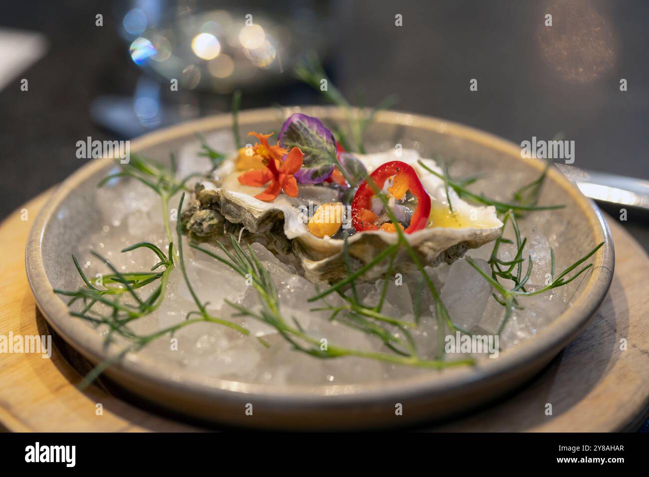 Oyster in a half shell with colorful garnish Stock Photo - Alamy