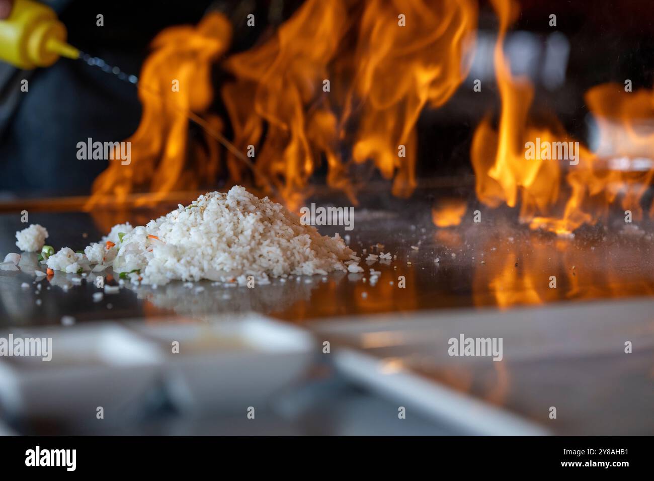 Rice cooks on teppan grill with flames in background Stock Photo - Alamy