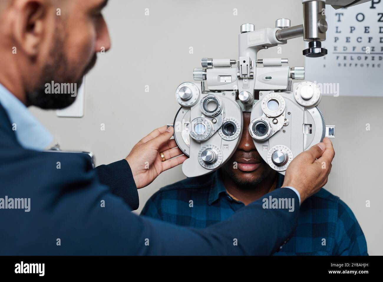 Optometrist Conducting Eye Examination with Phoropter on Patient in ...