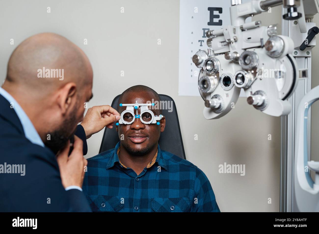 Optometrist Conducting Eye Examination on Client with Phoropter in ...