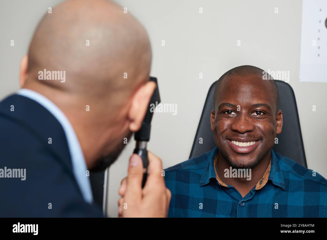 Optometrist Conducting Eye Examination for Smiling Patient in ...