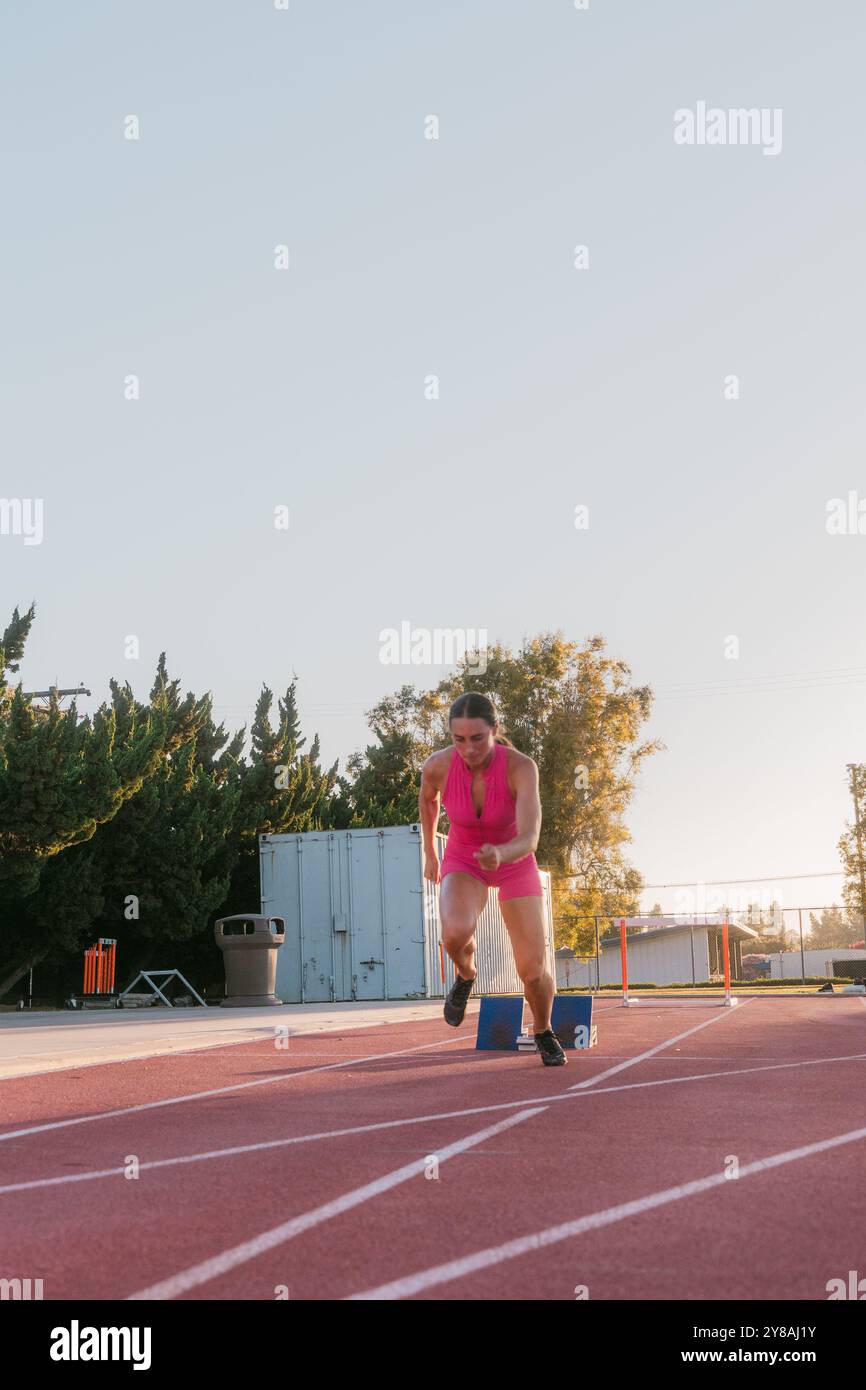 Female track athlete driving out of sprinter blocks Stock Photo - Alamy