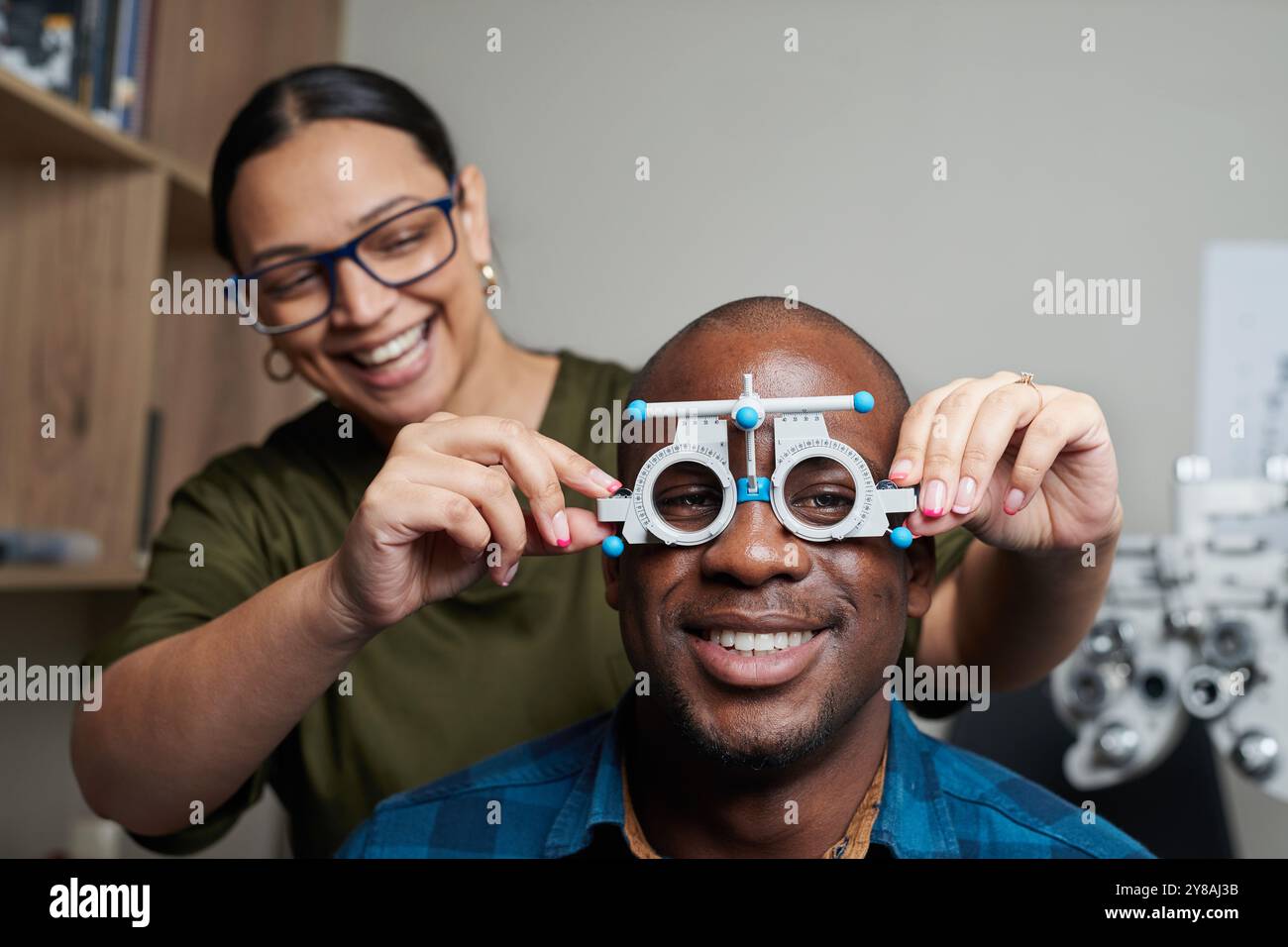 Optometrist Fitting Trial Frames for Smiling Patient in an Optometry ...