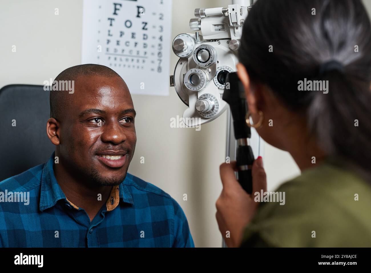 Optometrist Conducting Eye Exam for Smiling Man in Clinic Room With Eye ...