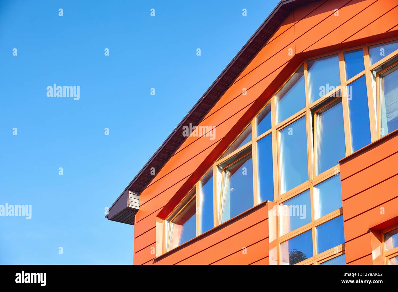 Wall of commercial building with large windows and orange metal ...