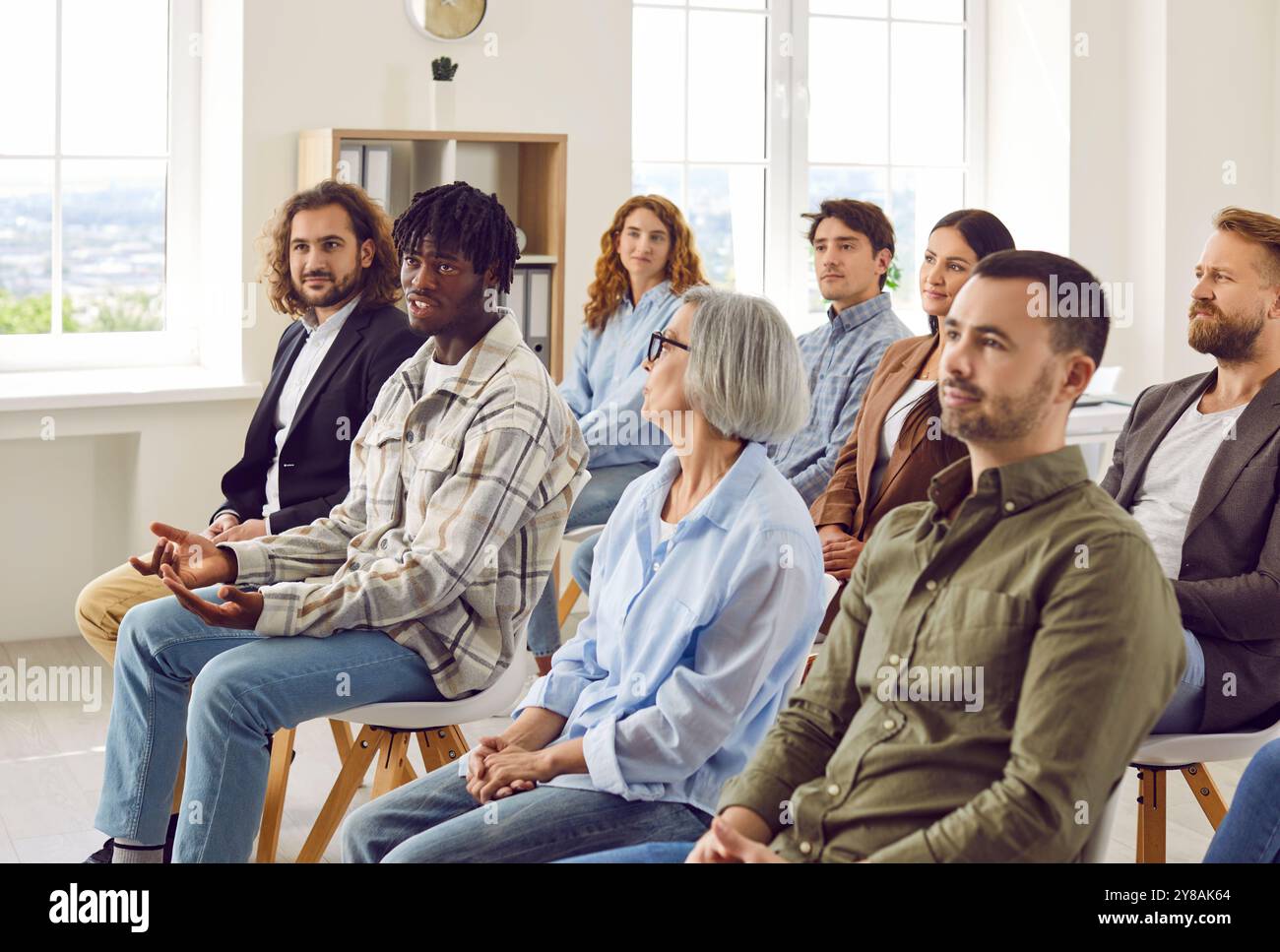 Multiethnic audience asking questions at public business conference ...