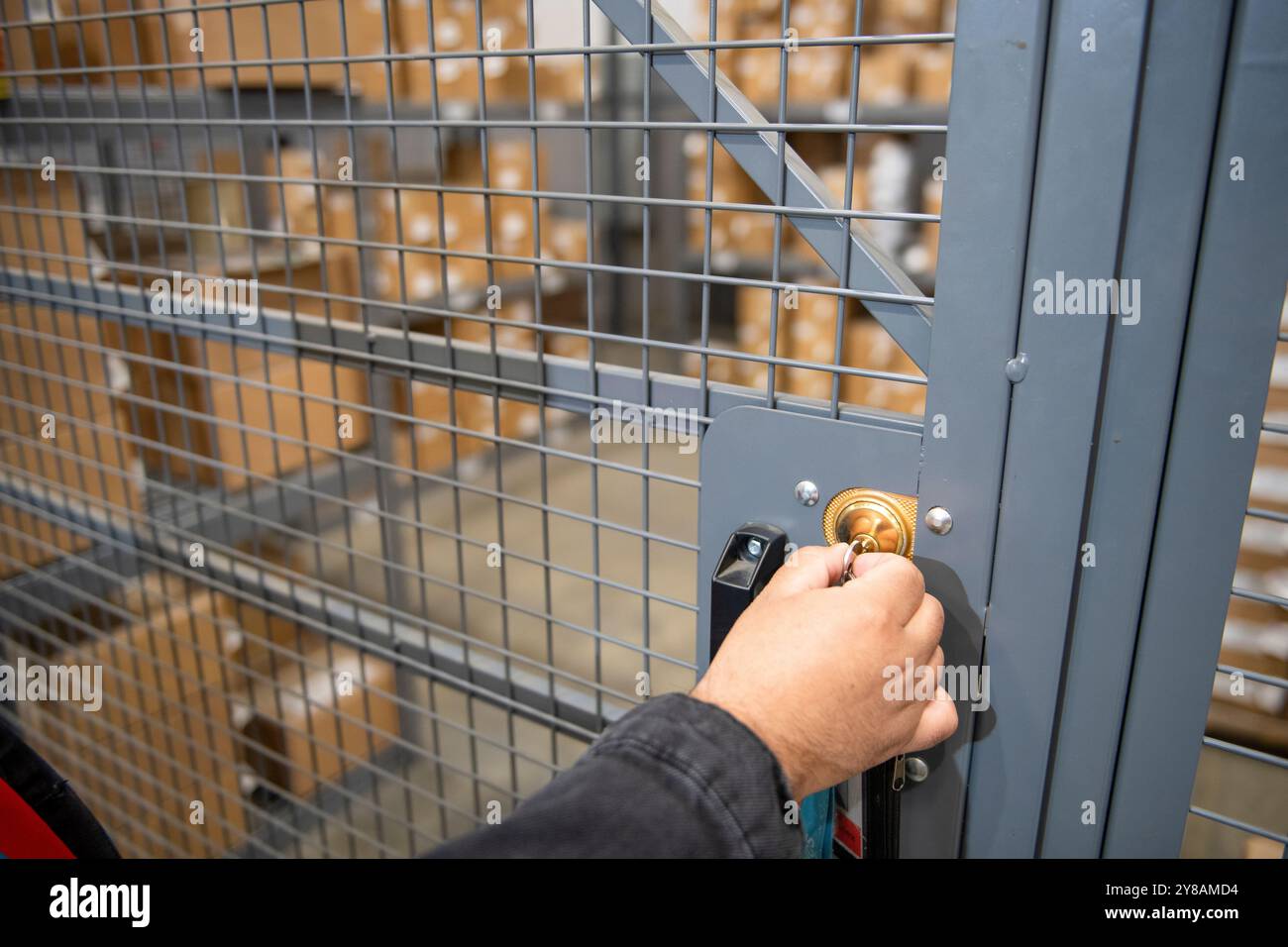 Worker turns key to lock of secure are in shipping warehouse Stock ...