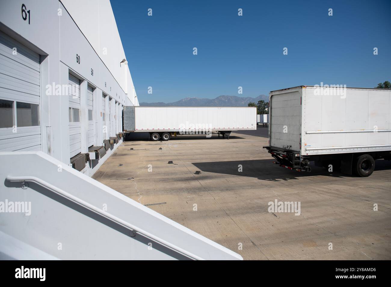 White box truck trailer backing into distribution warehouse bay Stock ...