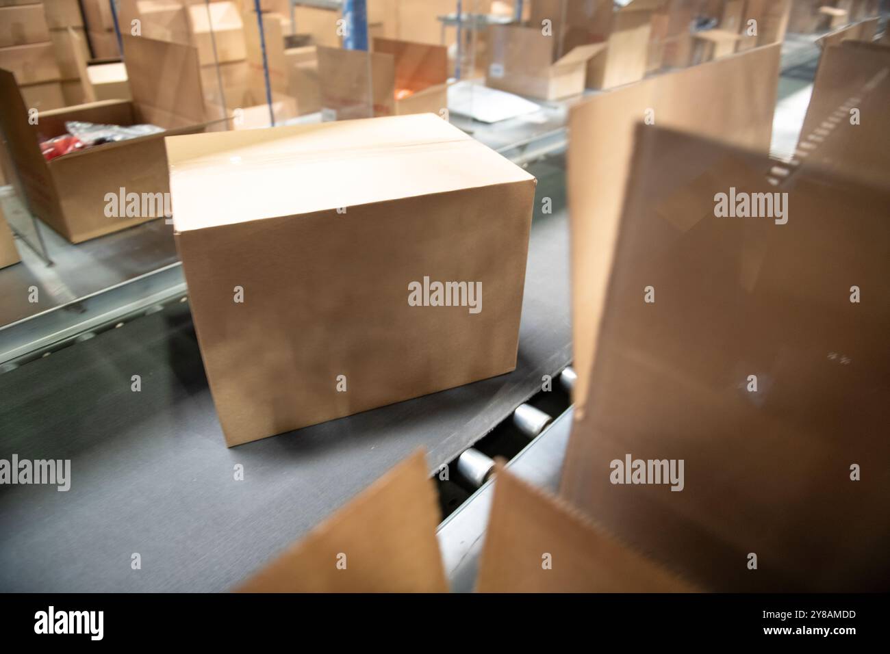 Shipping box moving through packing area on conveyor belt Stock Photo ...