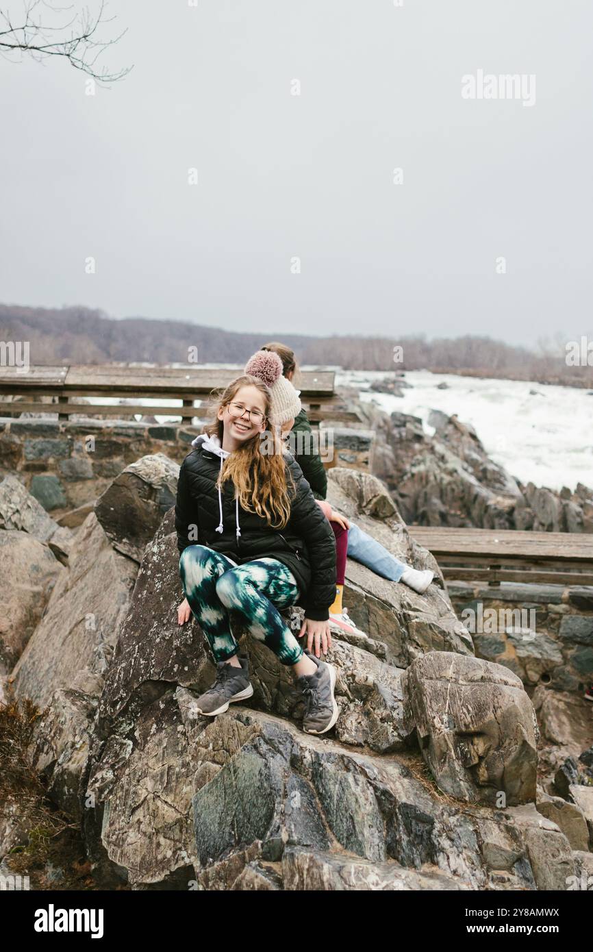 Tween girls climbing on rocks in valley with river in forest Stock ...