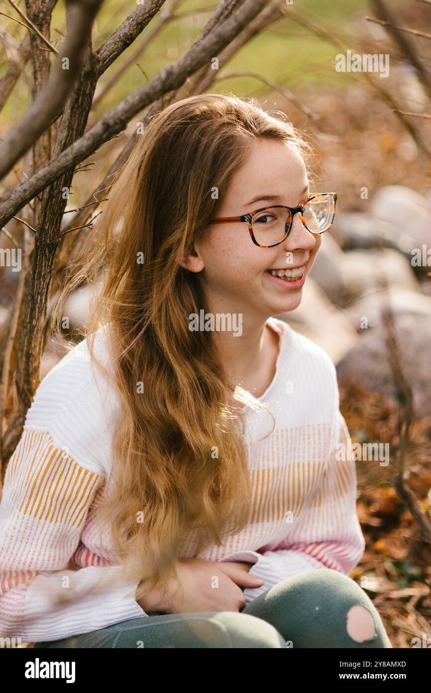 Tween girl in glasses with long blond hair smiles outside Stock Photo ...