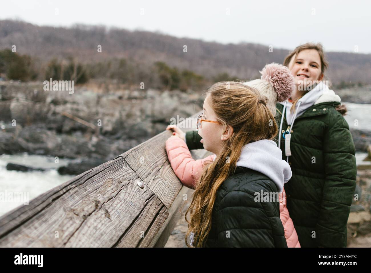 Tween girls overlook a river in coats in fall in mountain valley Stock ...