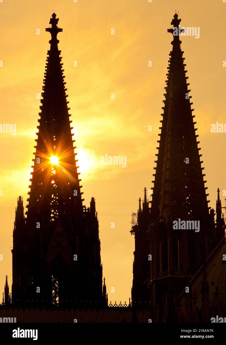 The sun shines through one of the two towers of Cologne Cathedral ...