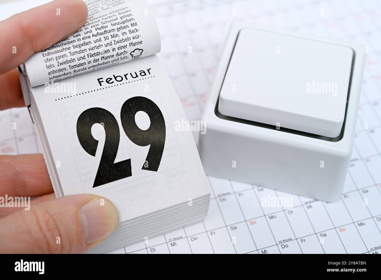 Hand with calendar page of February 29th and switch, symbol photo leap ...