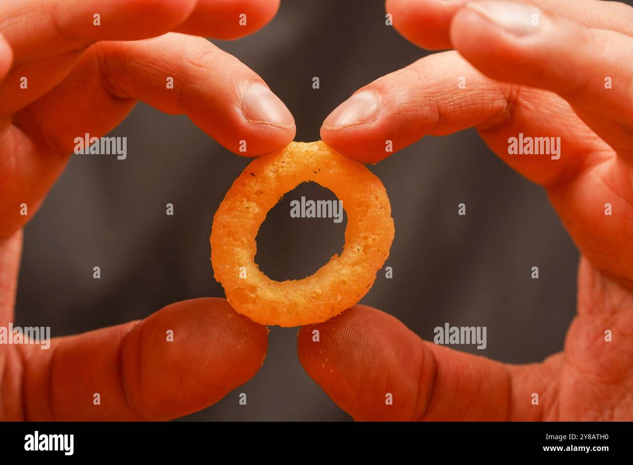 Man holds onion ring. Eating onion rings. Onion ring. Deep fried onion ...