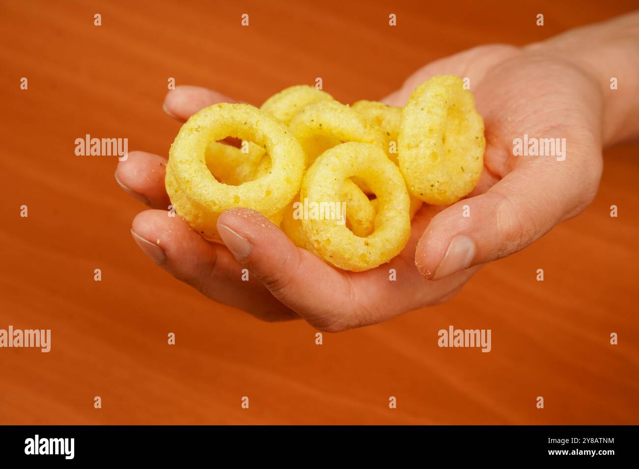 Man holds onion ring. Eating onion rings. Onion ring. Deep fried onion ...
