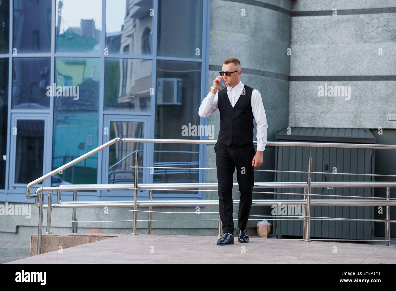 Stylish Businessman Walking Confidently While Talking on His Smartphone ...