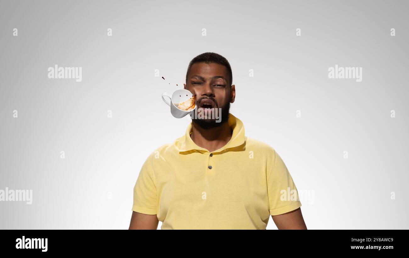 Cup of coffee hits man in motion square in face, spilling dark liquid ...