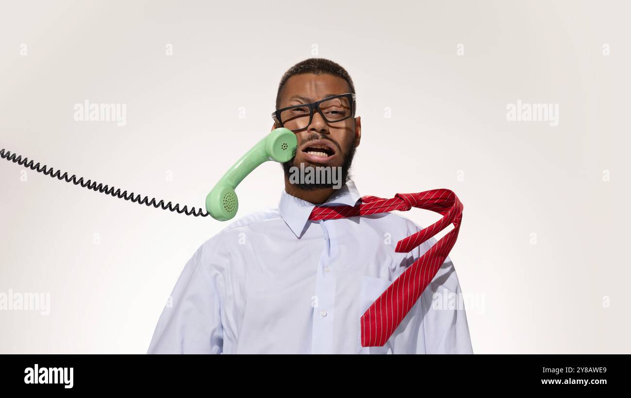 green rotary phone handset strikes man's face, his red tie flutters ...