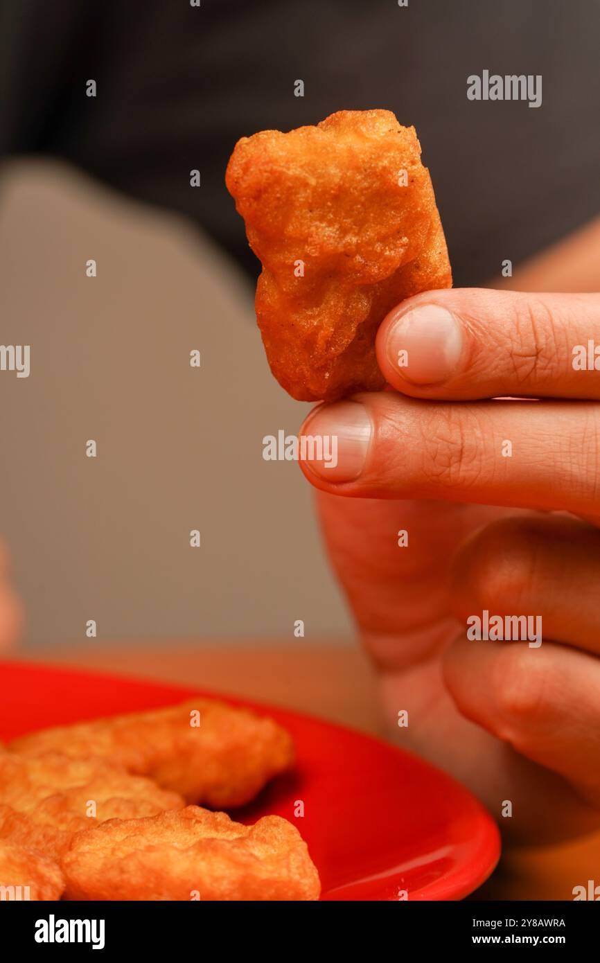 Chicken nuggets with ketchup. Holding chicken nuggets. Man eating ...