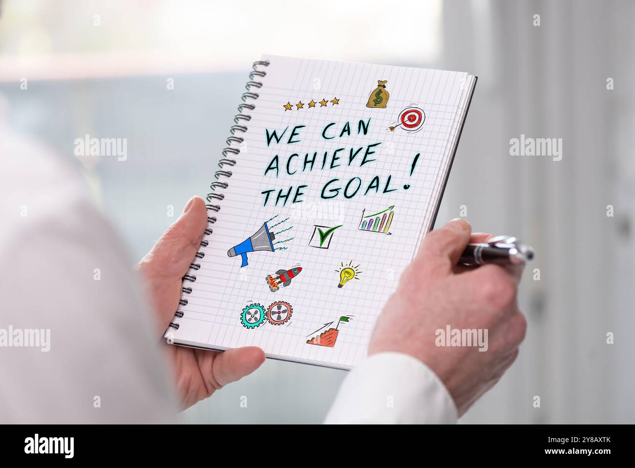 Hand holding a notepad with goal achievement concept Stock Photo - Alamy