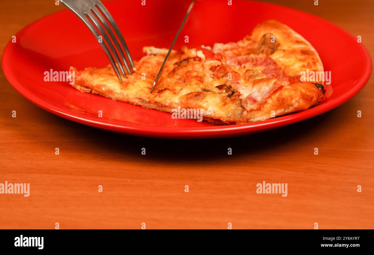 Cutting pizza slice on plate, close up view. Tasty food at pizzeria ...