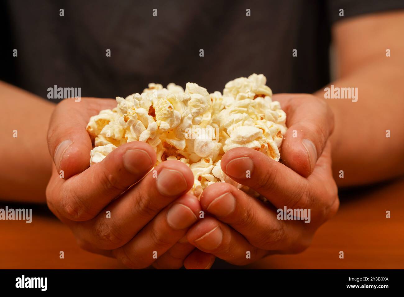 Flavored spicy popcorn in man's hands. Delicious snack to eat in the ...