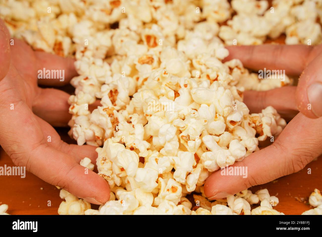 Flavored spicy popcorn in man's hands. Salted popcorn. Popcorn. Fast ...