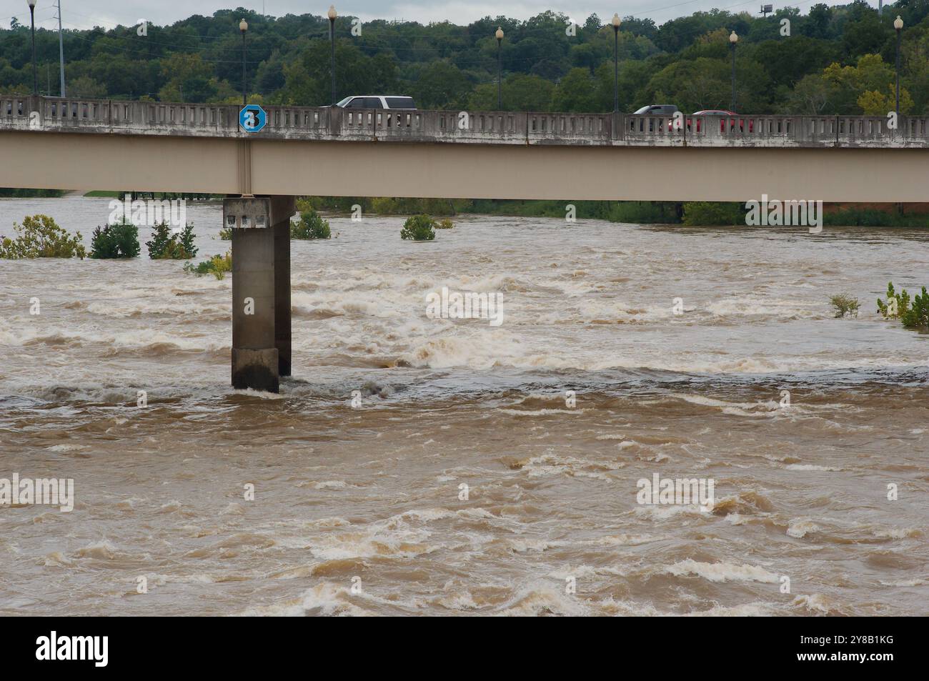 Wide Overhead view looking down at a swift fast moving, churning muddy ...