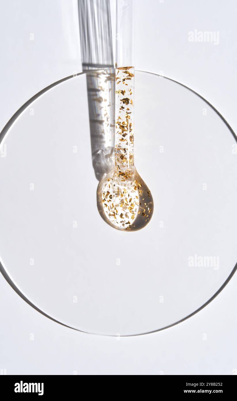 Elegant test tube with golden particles in clear liquid on transparent ...