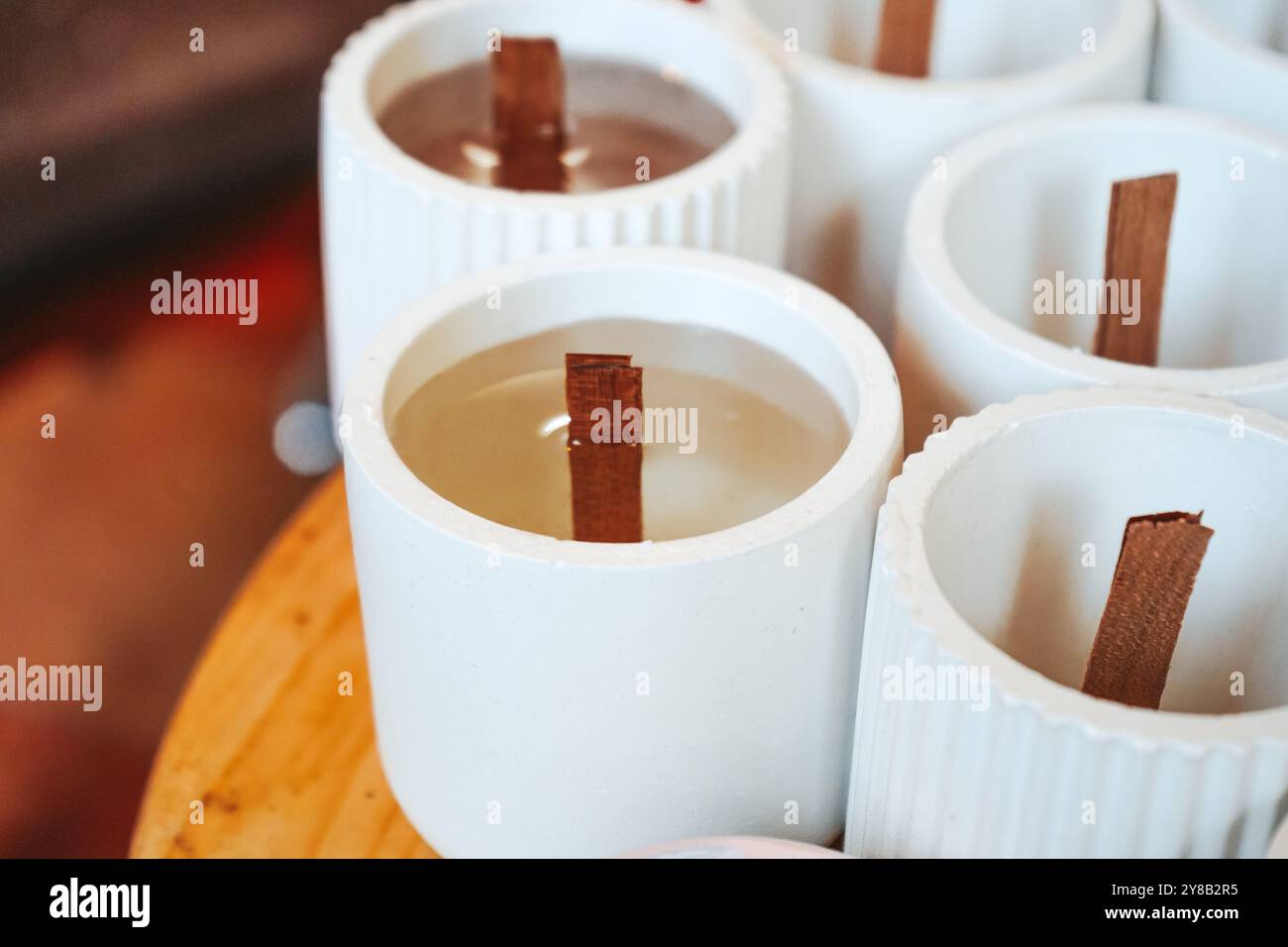 Craft wax candle. Process of pouring melted coconut wax and placing the ...